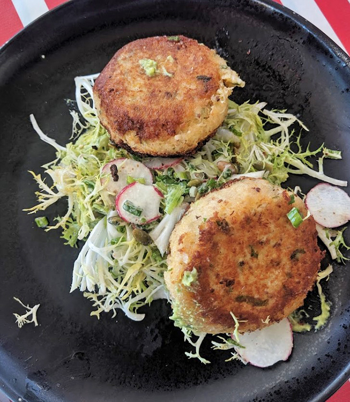 These golden crab cakes sitting pretty on greens know they're about to make someone very, very happy.
