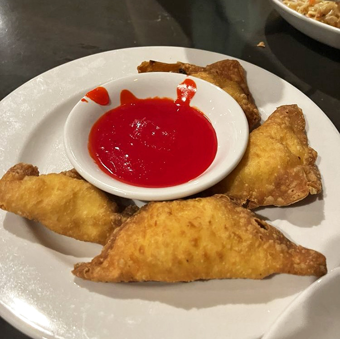 Golden-fried crab rangoon triangles with sweet-hot dipping sauce&mdash;the kind of appetizer that makes you consider canceling your entr&eacute;e altogether.
