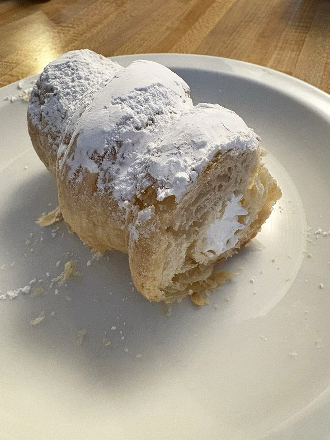 This cream horn doesn't just whisper sweetness&mdash;it announces it with a powdered sugar fanfare that makes napkins necessary but entirely worth it.