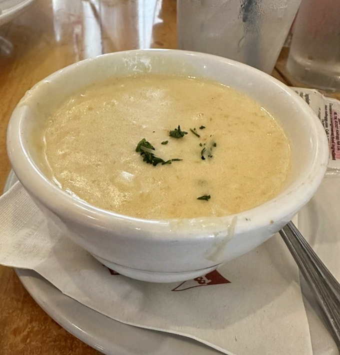 A bowl of cream of crab soup that's practically a hug in liquid form – velvety, rich, and sprinkled with just enough herbs to make it interesting.