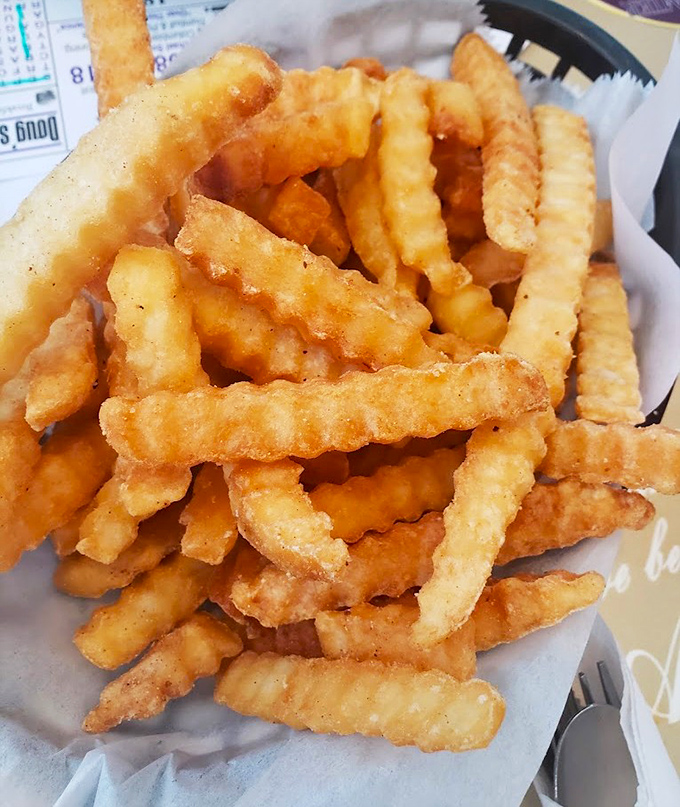 The krinkle-cut fries arrive like golden waves of potato perfection, demanding to be dunked in ketchup or devoured straight up.