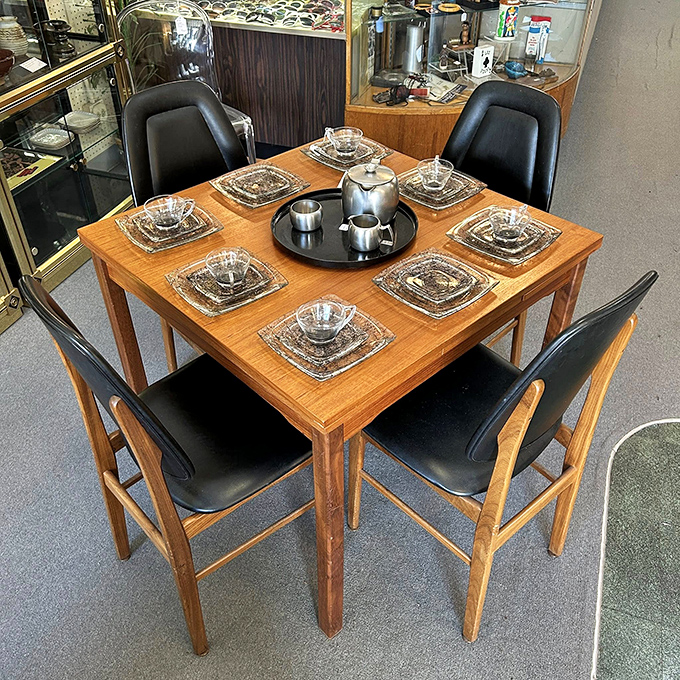 This teak dining set isn't just furniture; it's a time machine to family dinners circa 1965, complete with crystal glassware for your Old Fashioned.
