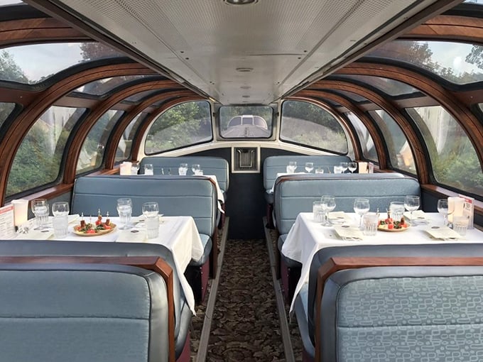 Fine dining meets scenic vistas in the glass-domed dining car, where white tablecloths and place settings await passengers seeking a meal with a moving view.