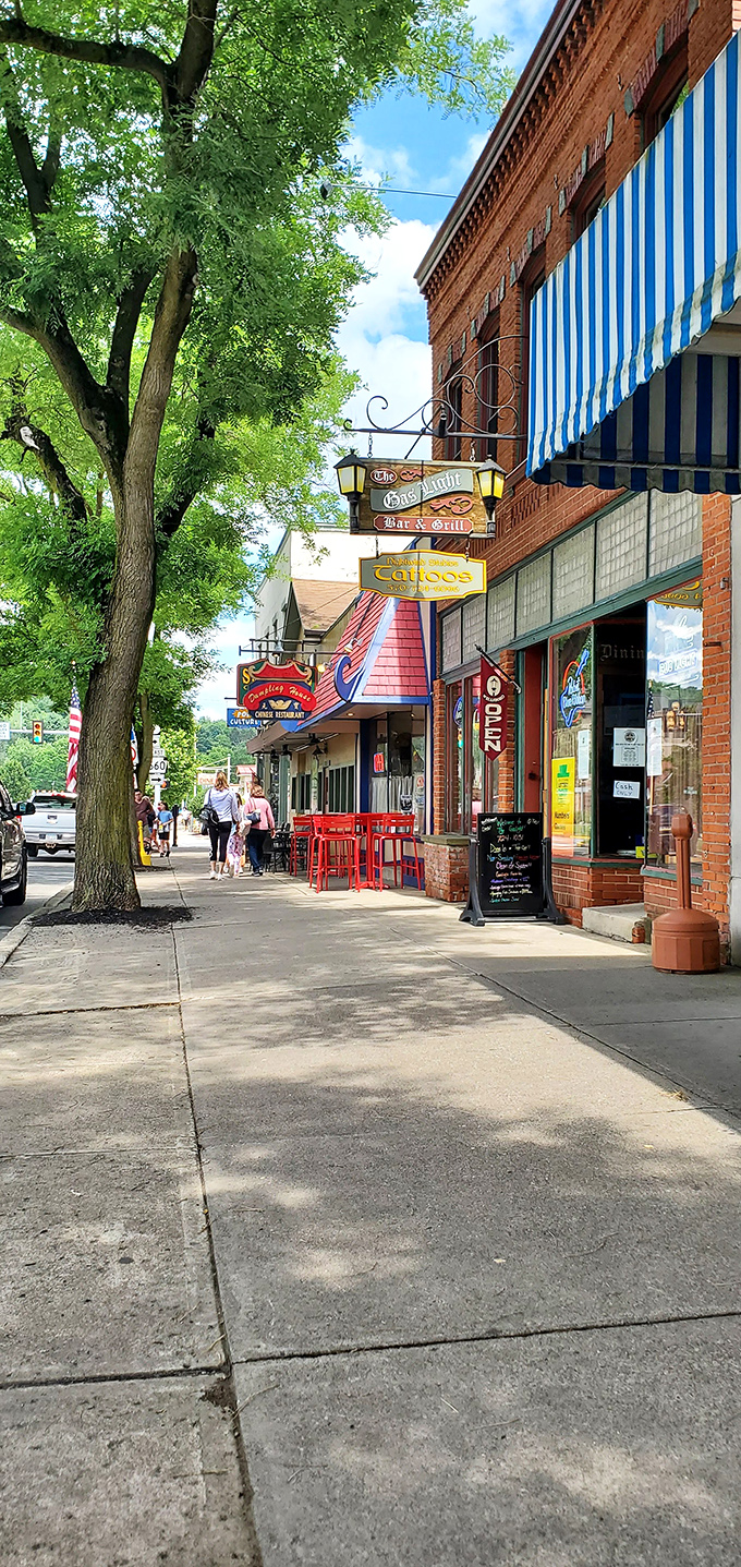 Hanging signs create an old-world marketplace feel along this stretch of shops, where The Gas Light Bar & Grill promises both illumination and libation.