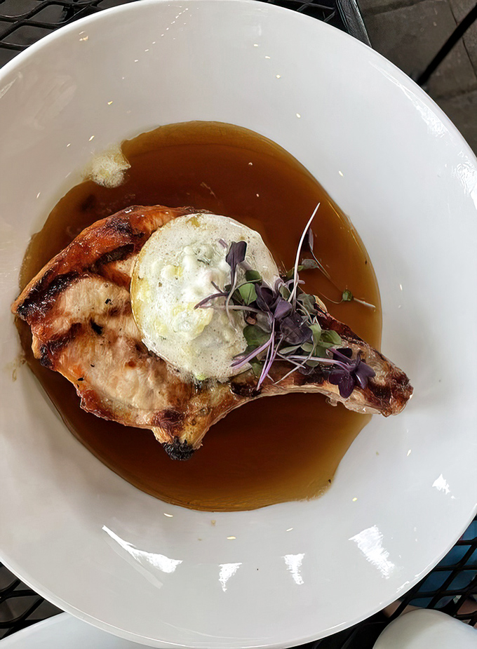 This pork chop isn't just dinner; it's a statement piece. The compound butter melting into the perfectly seared meat is pure theater.