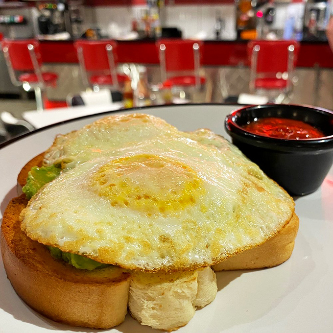 Breakfast perfection on Texas toast&mdash;a sunny-side-up egg crowning avocado like morning royalty, ready to make your day better with one perfect bite. 