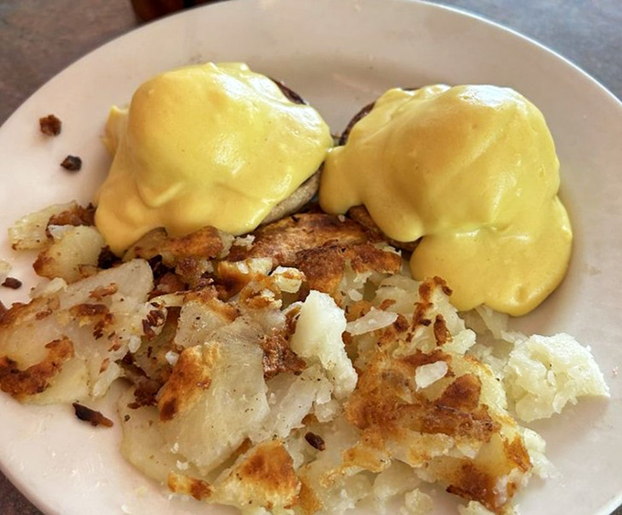 Eggs Benedict that would make the Pope jealous. That hollandaise sauce looks like liquid sunshine cascading over English muffin mountains. 