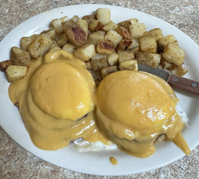 Eggs Benedict swimming in hollandaise heaven, with potatoes that actually taste like potatoes should.