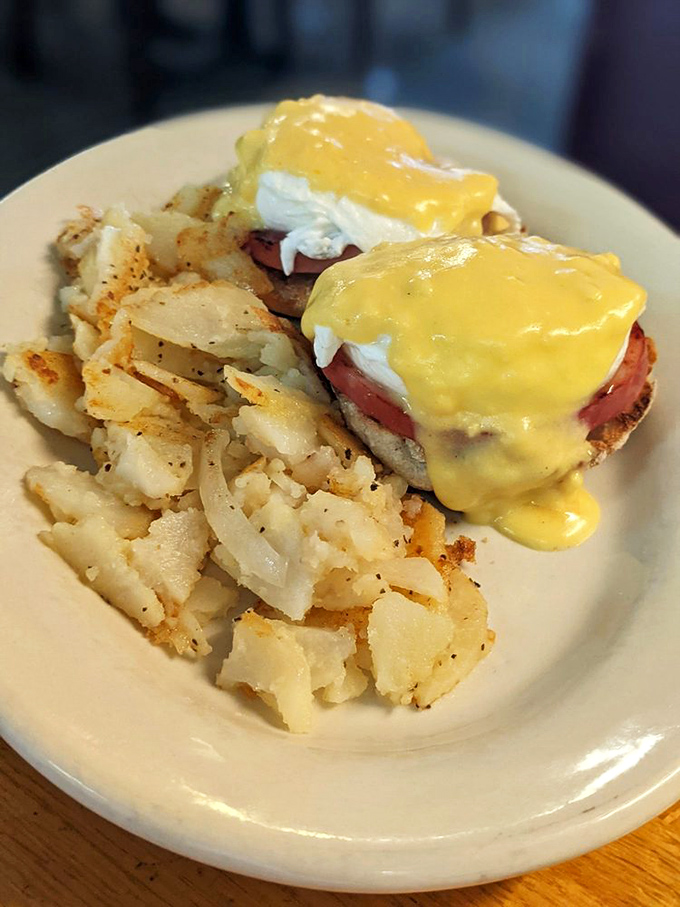 Eggs Benedict that would make the Pope jealous! Perfectly poached eggs nestled on Canadian bacon, crowned with hollandaise and flanked by home fries.