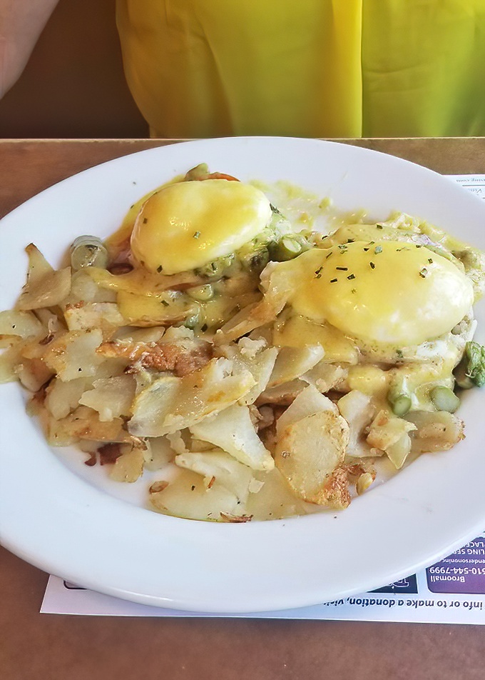 Eggs Benedict elevation: perfectly poached eggs drowning in hollandaise happiness on crispy hash browns.