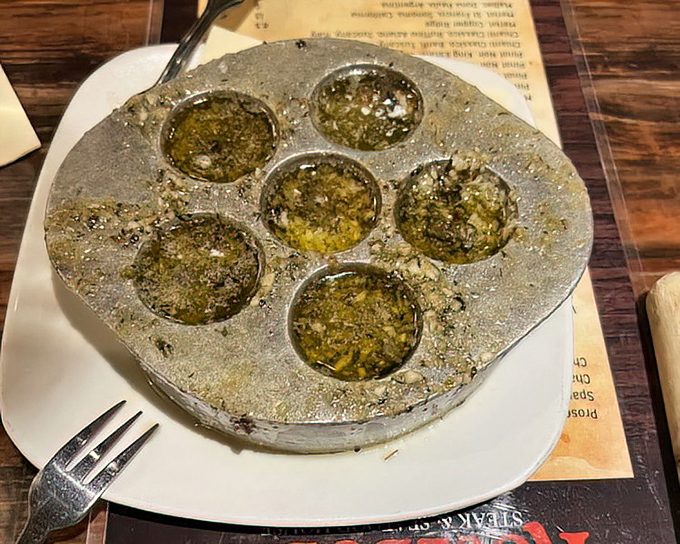 Escargot that would make a Frenchman weep with joy, nestled in their silver throne of buttery goodness.