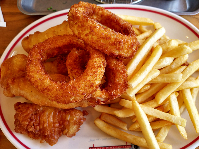 The onion rings and fries arrive like a golden tribute to the art of frying—crispy, light, and mysteriously vanishing from the plate faster than you can explain.