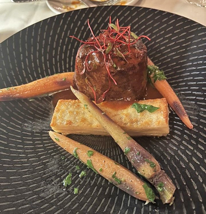 The filet mignon arrives like royalty on its throne of potato, surrounded by perfectly roasted carrots and a sauce worth bottling for later.