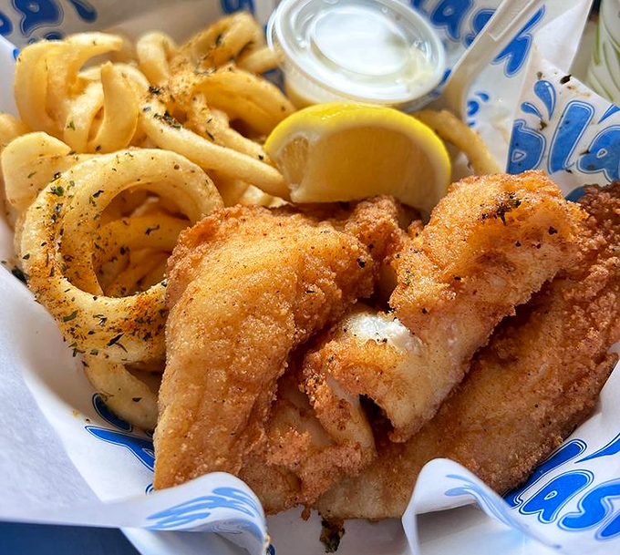 Fish and chips that would make a British pub jealous. The batter shatters like glass, revealing steamy, flaky white fish beneath.