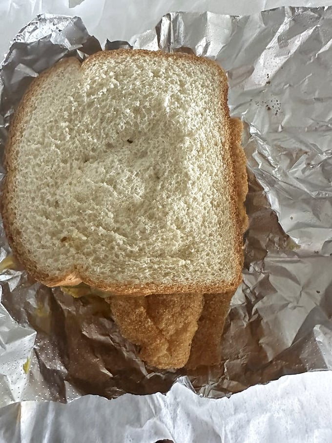 The sandwich opened up reveals its secrets&mdash;perfectly fried fish that extends well beyond the bread's borders. This is value you can see.
