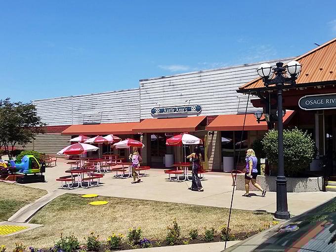 Red umbrellas dot this cheerful outdoor dining area, offering weary shoppers a perfect pit stop between retail adventures.