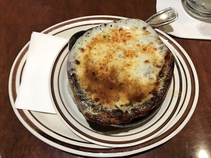 This isn't just French onion soup – it's a bubbling cauldron of comfort topped with a cheese lid so perfect it deserves its own Instagram account.