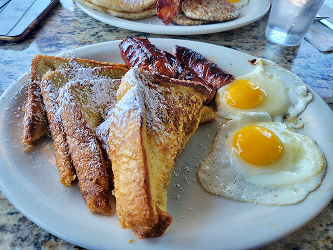 French toast thick enough to double as breakfast architecture, served with eggs and bacon backup dancers.