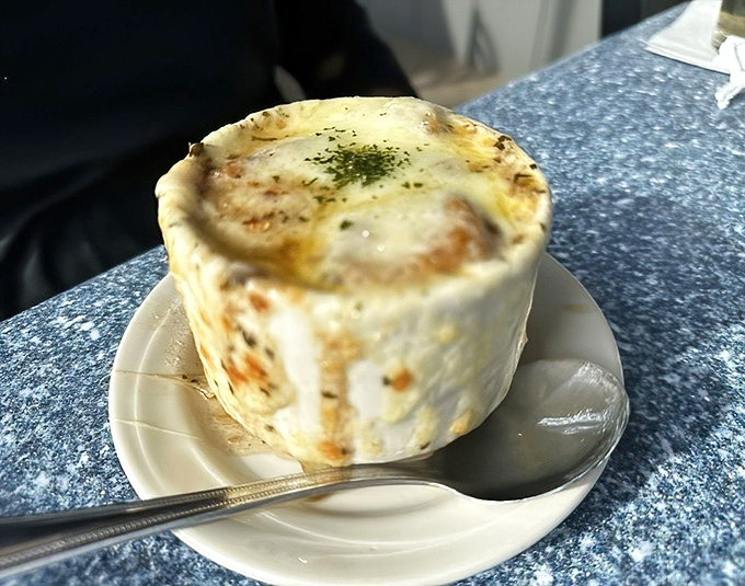 French onion soup with a crown of melted cheese that would make Louis XIV jealous &ndash; worth every moment of post-meal breath mint necessity.