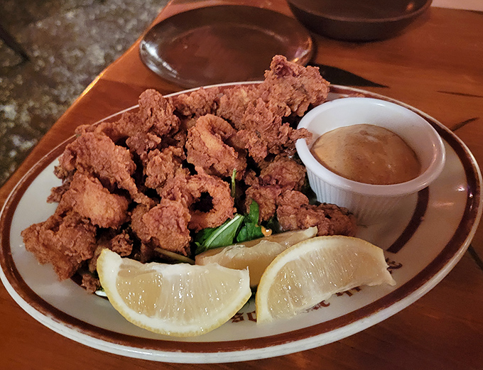 Crispy calamari that crunches like autumn leaves, served with lemon wedges that cut through the richness perfectly. The dipping sauce is non-negotiable.