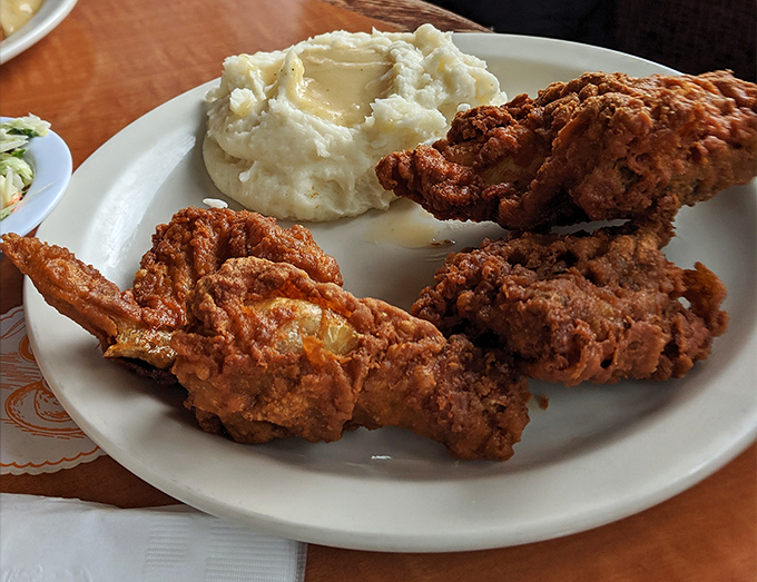 Fried chicken with a crust so audibly crunchy it drowns out conversation, paired with mashed potatoes that could make a carb-counter weep with joy.