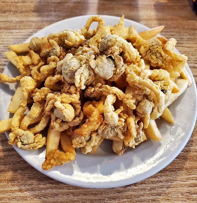 Fried clams and fries piled high like a delicious Jenga tower that you'll happily dismantle one crispy bite at a time.