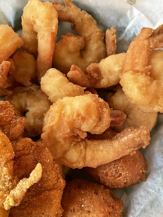 Fried shrimp that snap with freshness beneath their golden armor, ready to be dipped in sauce or devoured straight from their paper-lined basket.
