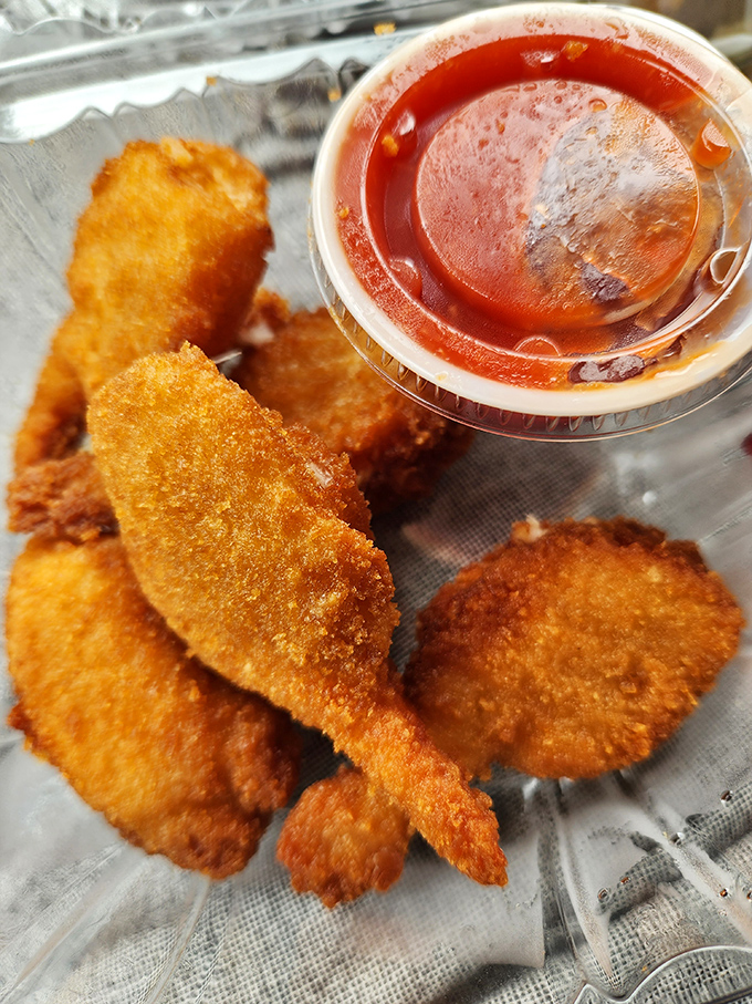 Fried seafood that achieves the impossible: a delicate crunch giving way to tender sweetness, with dipping sauce standing by for extra flavor duty.