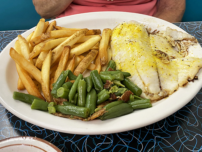 Simple pleasures done right: perfectly fried tilapia with crispy fries and green beans. No foam, no "deconstructed" nonsense&mdash;just food that makes you happy.