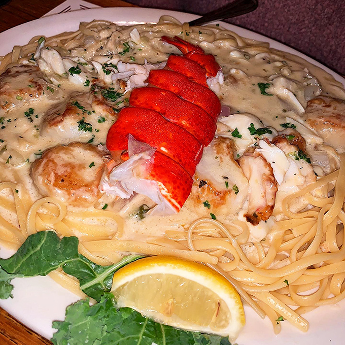 Lobster tail crowning a throne of fruit de mare pasta—the seafood equivalent of hitting the lottery and finding out you also get free ice cream for life.