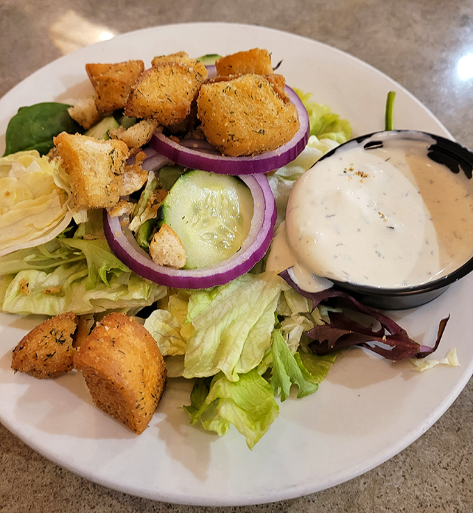 A garden-fresh Greek salad that somehow makes virtue feel indulgent. Those homemade croutons deserve their own fan club.