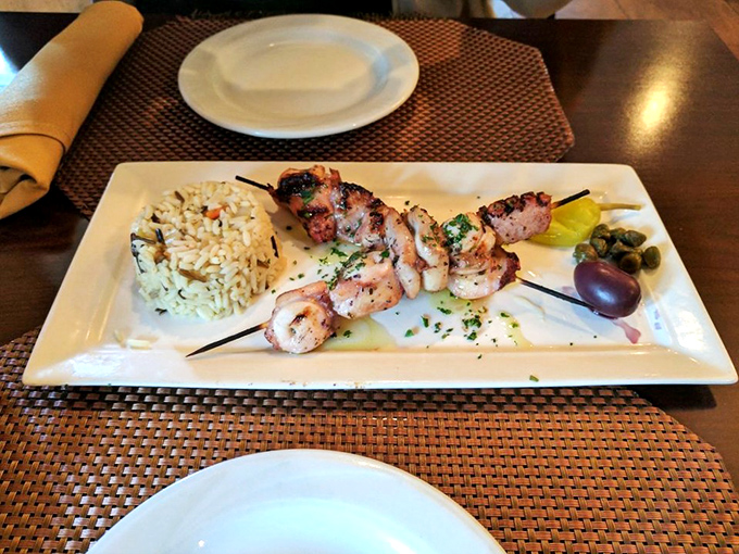 Grilled octopus that would make a Greek grandmother nod in approval, served with rice pilaf and a garnish of Mediterranean authenticity.
