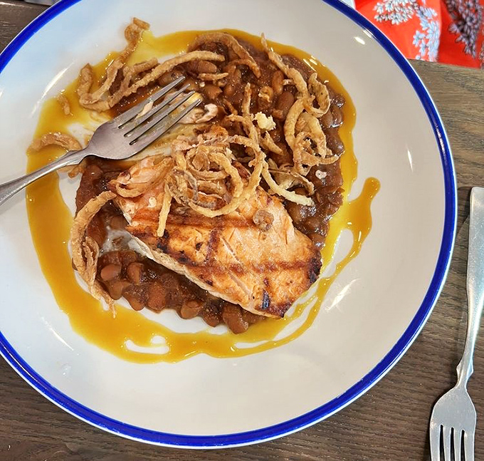 A perfectly seared salmon rests on a bed of vibrant green beans. The sauce? I'd happily drink it with a straw when nobody's looking.