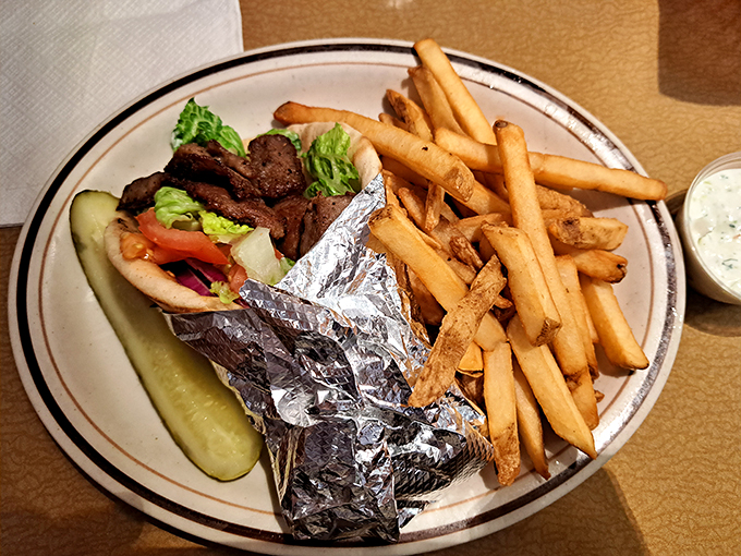 A proper gyro wrapped in foil like the precious gift it is, with fries that look like they've achieved the perfect crisp-to-fluffy ratio.