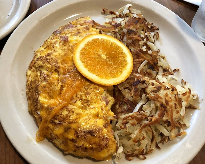 This omelet has more cheese than my uncle's jokes at Thanksgiving dinner. The orange slice isn't just garnish&mdash;it's a vitamin C life raft in a sea of delicious indulgence.