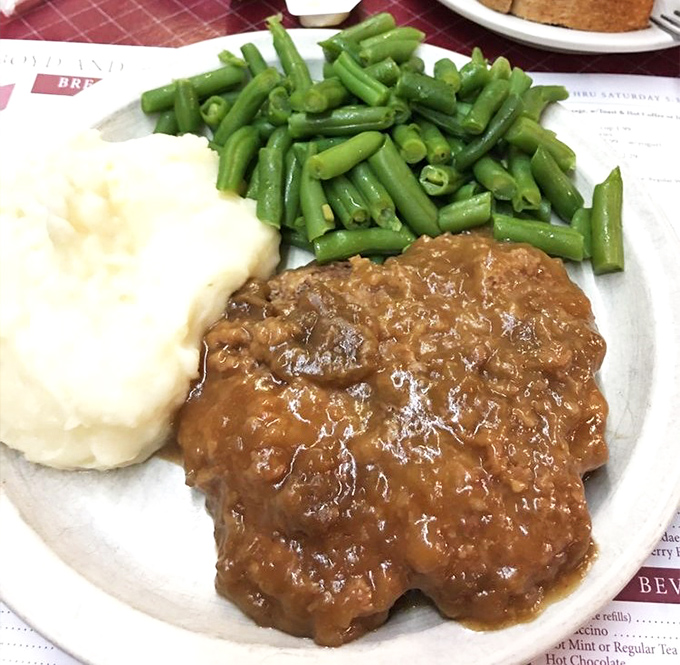 A hamburger steak that doesn't need fancy aioli or artisanal buns&mdash;just green beans and mashed potatoes to complete this trifecta of satisfaction.