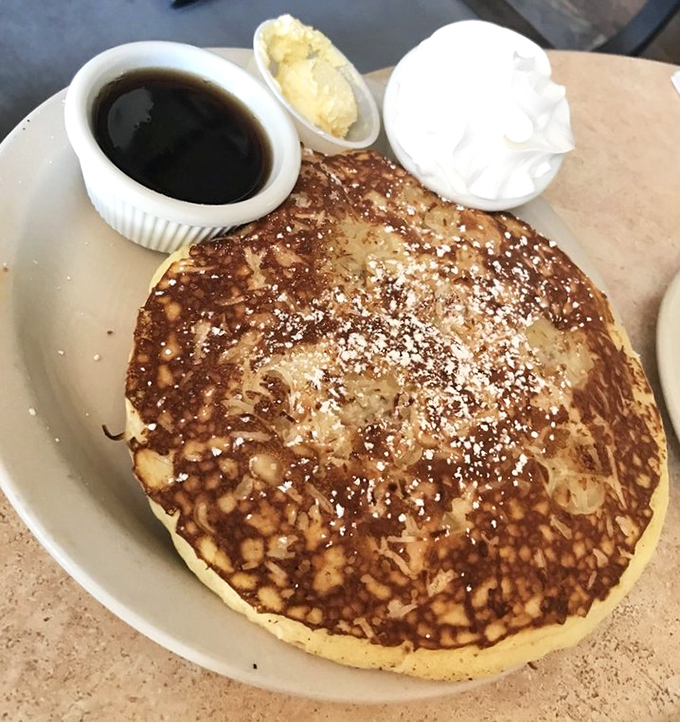 This golden pancake isn't just breakfast, it's a buttery canvas of possibility, served with the kind of maple syrup that makes you question all other sweeteners.