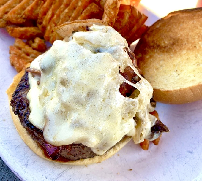 A burger so gloriously smothered in melted cheese it looks like it's wearing a delicious winter coat.