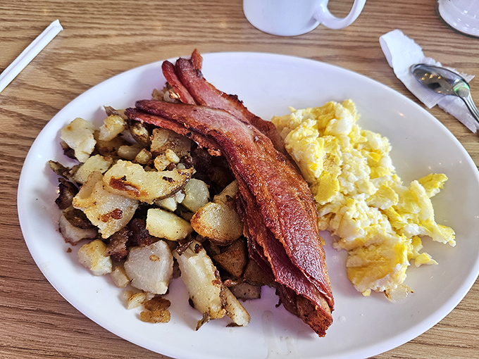 The breakfast trinity: perfectly crispy potatoes, eggs that know exactly what they're doing, and bacon that deserves its own fan club.