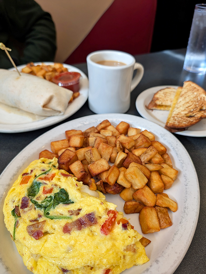 An omelet bursting with colorful vegetables alongside perfectly crisped home fries&mdash;breakfast that's both art and science.