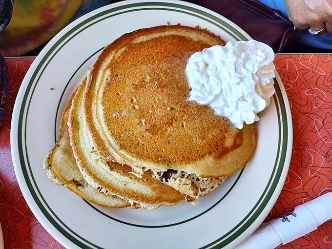 Golden pancakes with a dollop of whipped cream—these fluffy discs of joy are the runway where maple syrup makes a perfect landing.