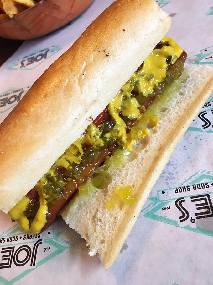 The hot dog arrives dressed to impress with vibrant yellow mustard and relish &ndash; simple perfection that needs no black tie invitation.