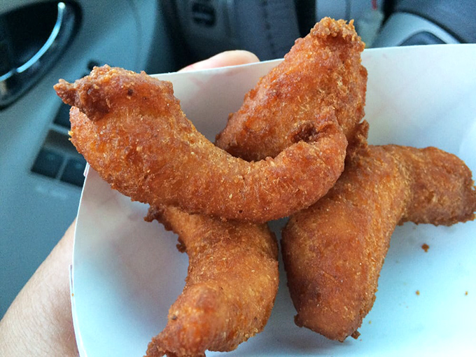 Golden-brown hush puppies standing at attention. These crispy cornmeal sentinels have been silencing hunger pangs for generations.