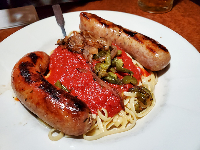 Italian sausages lounging on a bed of pasta like they own the place, draped in a tomato sauce that means business. 