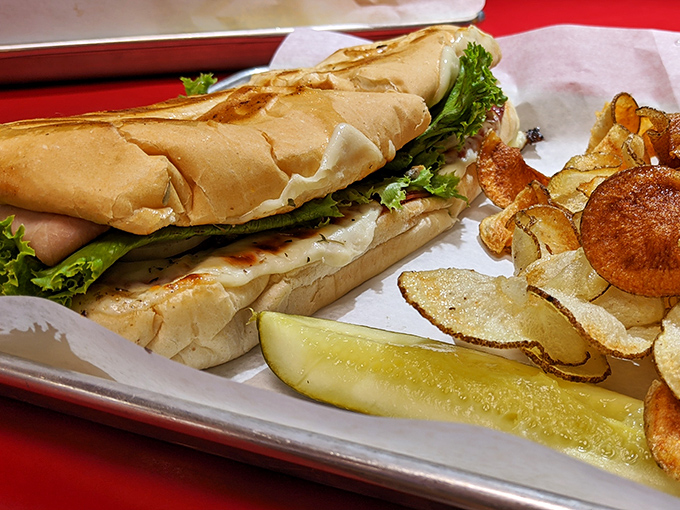 A sandwich that understands the importance of proper bread-to-filling ratio, served with house-made chips that make store-bought versions weep with inadequacy.