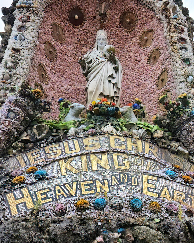 "Jesus Christ King of Heaven and Earth" proclaims this shrine, where pink stones create a backdrop worthy of celestial royalty.