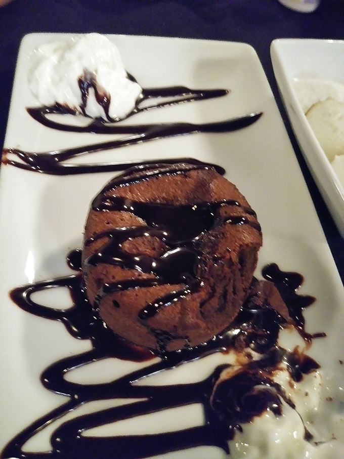 Chocolate lava cake with its molten center performing a sweet magic trick on your plate. The ice cream is just there to witness the miracle.