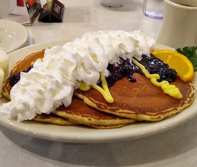 Pancake perfection! These golden discs topped with whipped cream and blueberry compote are what breakfast dreams are made of.