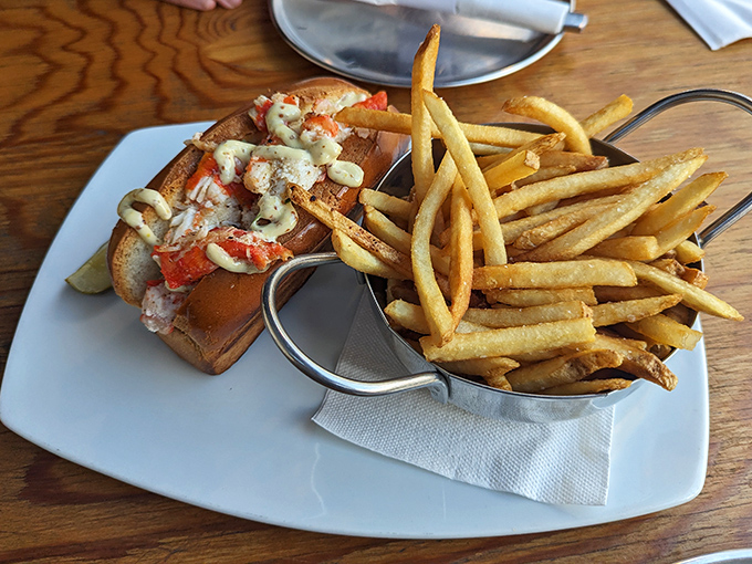 The lobster roll that launched a thousand return visits – sweet meat nestled in buttery bread with fries standing at attention like golden soldiers.