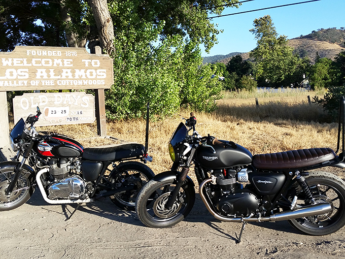Two motorcycles rest at the town's entrance sign&mdash;modern-day horses for travelers exploring "The Valley of the Cottonwoods."